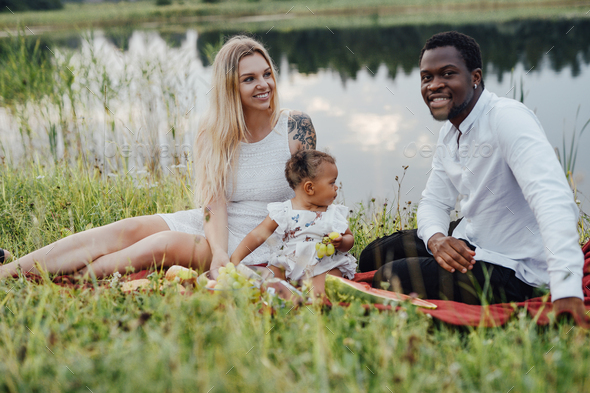 Joyful family of mixed race couple and their child Stock Photo by fxquadro