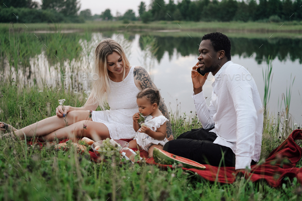 Joyful family of mixed race couple and their child Stock Photo by fxquadro