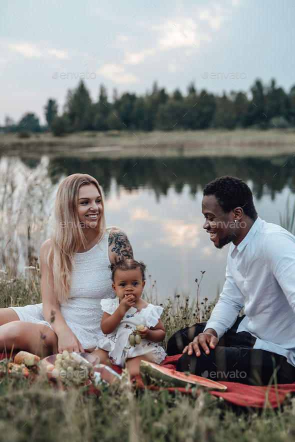 Joyful family of mixed race couple and their child Stock Photo by fxquadro