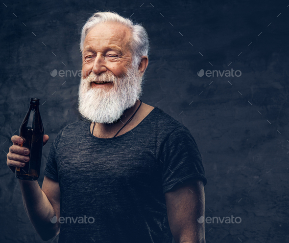 Joyful old man with bottle posing against dark background Stock Photo ...