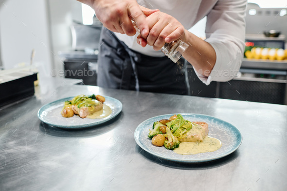 Chef adding spices on dish before serving Stock Photo by AnnaStills