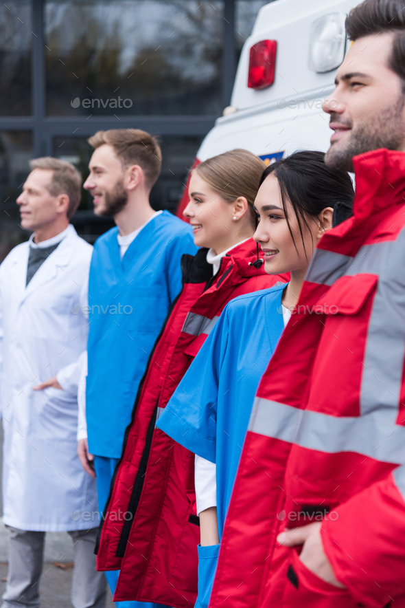 side view of paramedics working team standing in front of car Stock ...