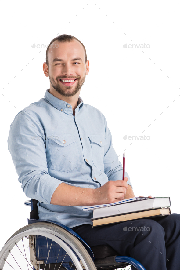 Smiling physically handicapped man on wheelchair with books and pencil ...