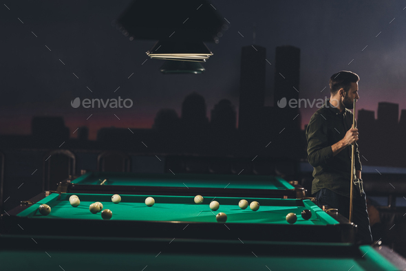successful handsome man standing beside pool table at bar Stock Photo ...