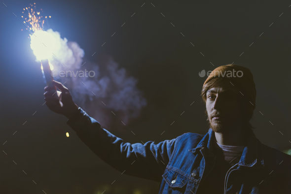 man holsing smoke bomb with sparks at night Stock Photo by ...