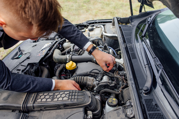 Car breakdown. close up of Concentrated young man try to repair the ...