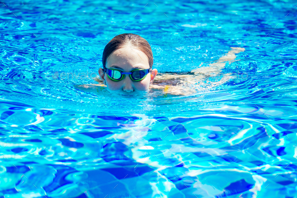 beautiful young armless woman training to swim in pool at tropical ...