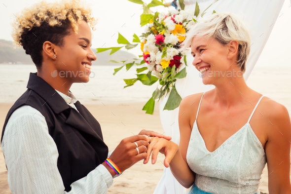african american female groom in black suit and happy caucasian blonde ...