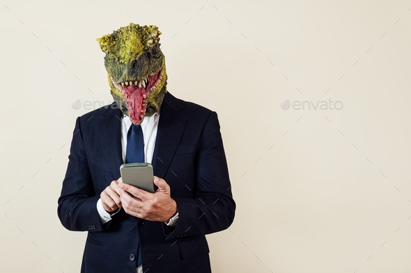 Euphoric man with lizard head with smart phone. Stock Photo by karrastock