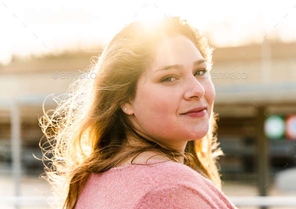 Beautiful plus size young woman outdoors Stock Photo by oneinchpunchphotos