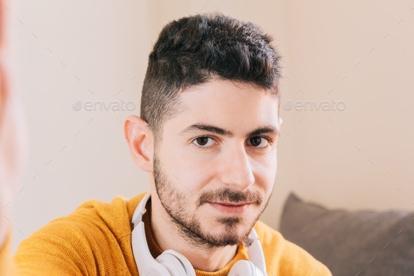 Young adult man in his 30s taking a selfie photo with his mobile phone ...