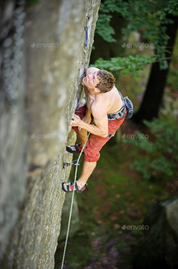 Muscular rock climber climbs on cliff wall with rope Stock Photo by ...