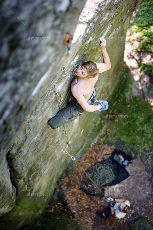 Muscular rock climber climbs on cliff wall with rope Stock Photo by ...
