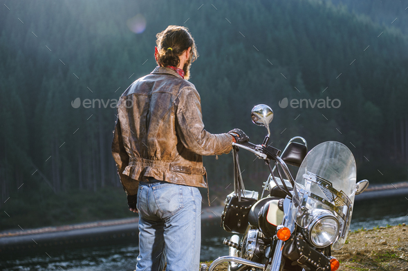 Biker standing by his custom made cruiser motorcycle Stock Photo by ...