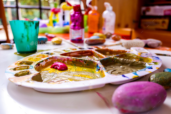 Children choosing colors in a paint palette with a brush enjoying art ...