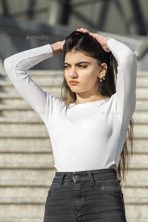 Vertical photo of young girl on the stairs stretching her hair Stock Photo by 13people