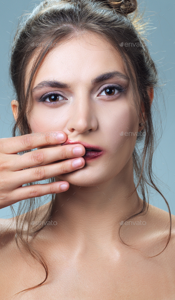 Portrait of beautiful girl with clean skin smearing lipstick from lips ...