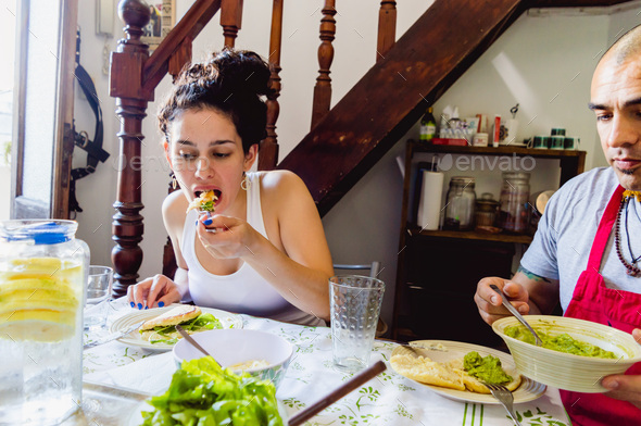 caucasian woman eating arepa enjoying lunch with her husband at home ...