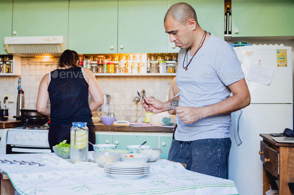 man in the kitchen standing by the table arranging and serving the ...