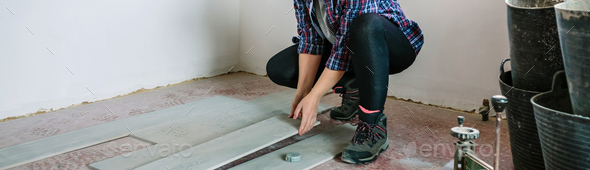 Female bricklayer placing tiles to install a floor Stock Photo by ...