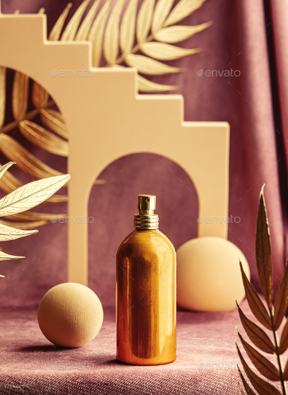 presentation of golden perfume bottle next to geometric shapes and palm ...
