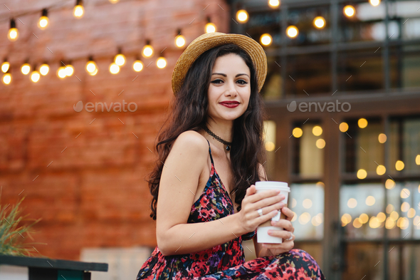 Female with dark long hair, having pure healthy skin, wearing straw hat ...