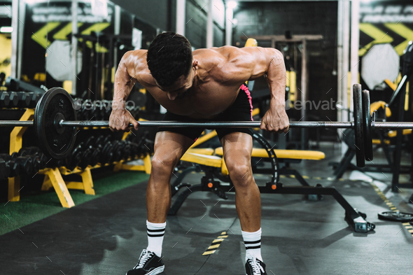 Strongman lifting weights with the barbell in a gym Stock Photo by ...