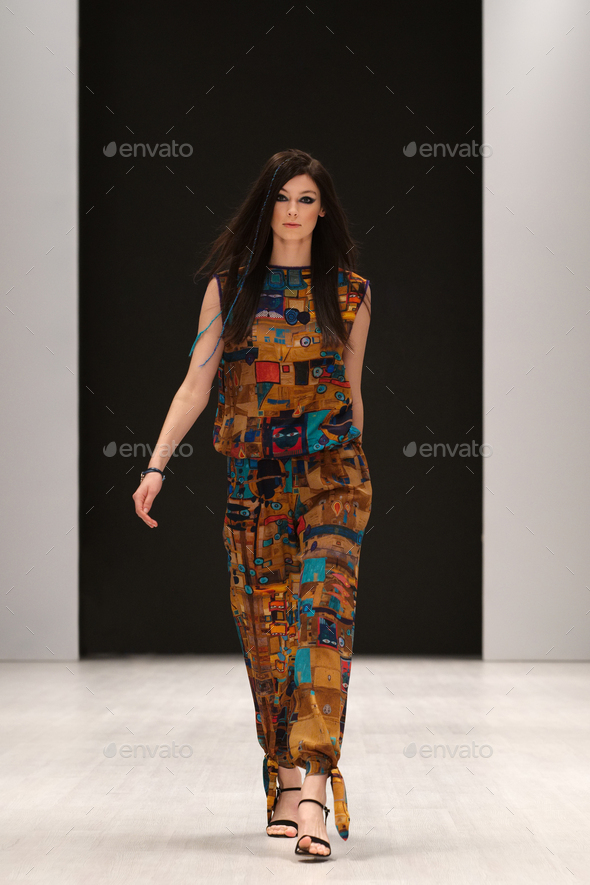 Fashion model in wool coat and knitted dress walking on podium during ...