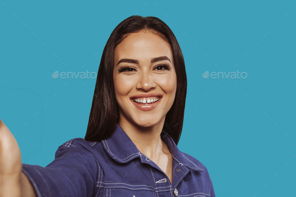 Cheerful arabic girl taking selfie and sincerely laughing Stock Photo by carlesmiro