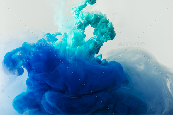 Close up view of mixing of blue and turquoise inks splashes in water ...