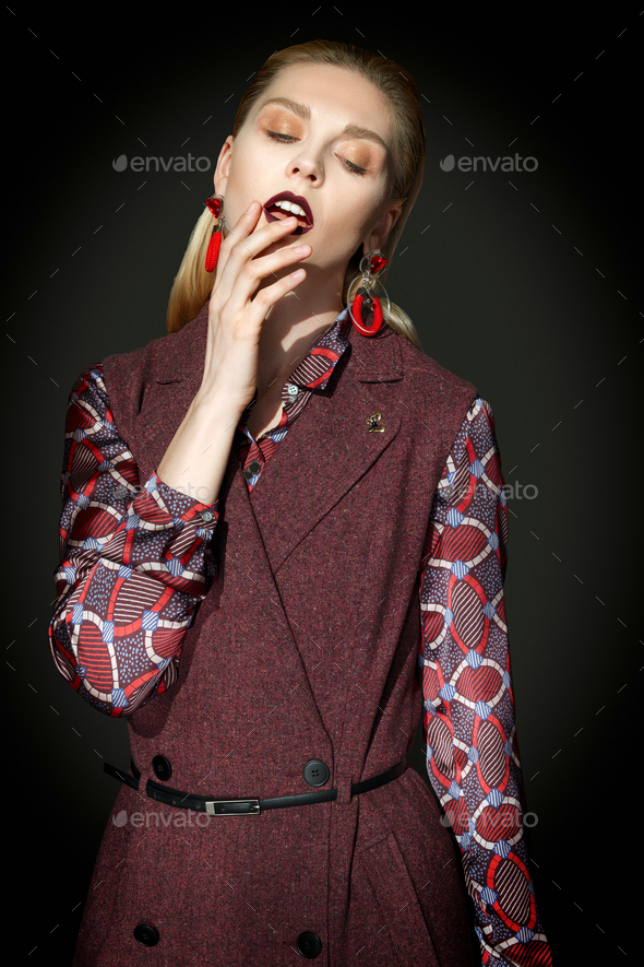Portrait of beautiful fashion model touching her lips with fingers ...