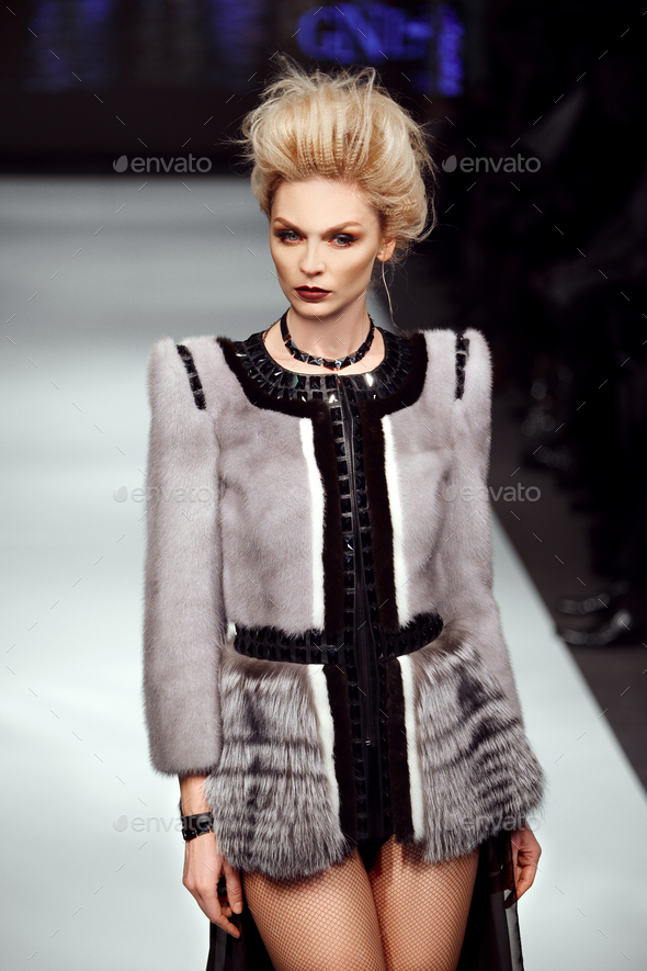 Fashion model walks on runway in fur coat. Stock Photo by boomeart