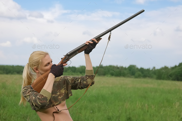 Attractive hunter girl aiming with hunting double-barreled rifle Stock ...
