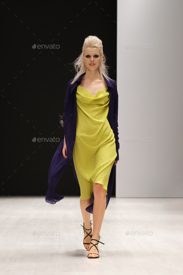 Fashion model in silk dress walking on podium during fashion week show ...