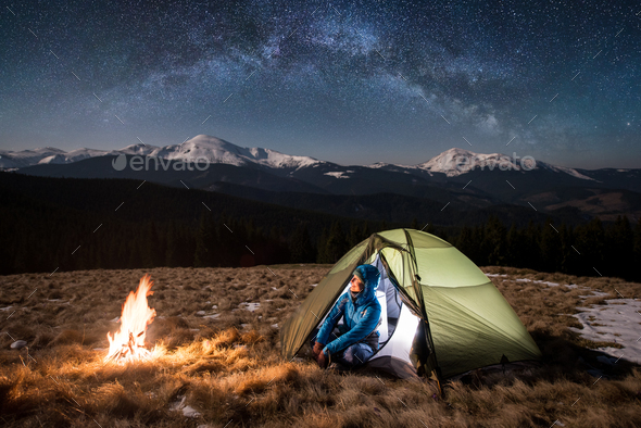 Female tourist enjoying in her camp at night under beautiful sky full ...
