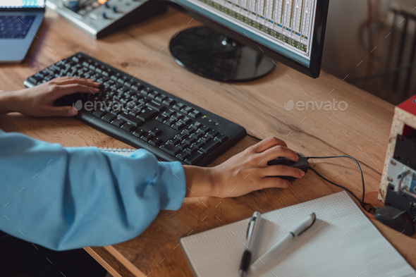 Keyboard and computer mouse on wooden desk in front of monitor screen ...