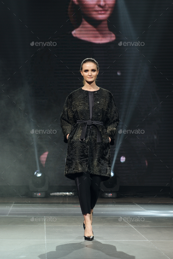 Beautiful fashion model walks on runway in fur coat Stock Photo by boomeart
