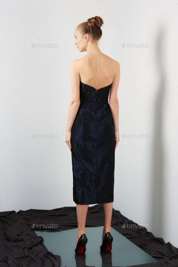 Fashion model in cocktail dress with buttons and without shoulder ...