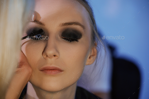 Soft focus photo of eyes makeup process. Makeup artist applies ...