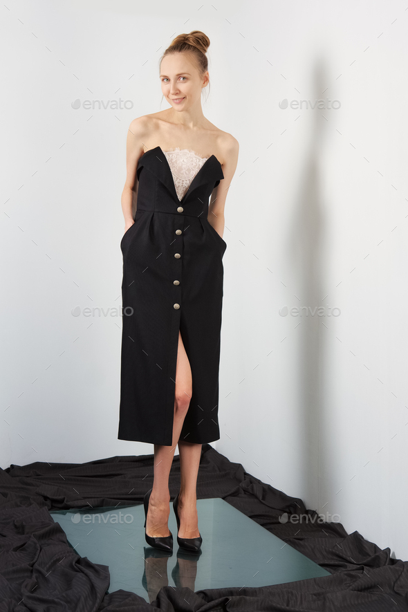 Fashion model in cocktail dress with buttons and without shoulder ...