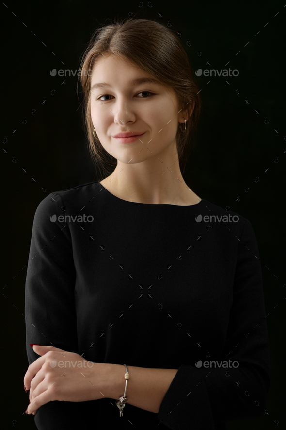 Low key portrait of pretty girl in short dress posing on dark ...