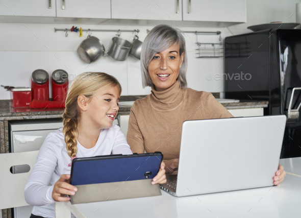 mother with laptop computer and daughter with tablet computer Stock ...