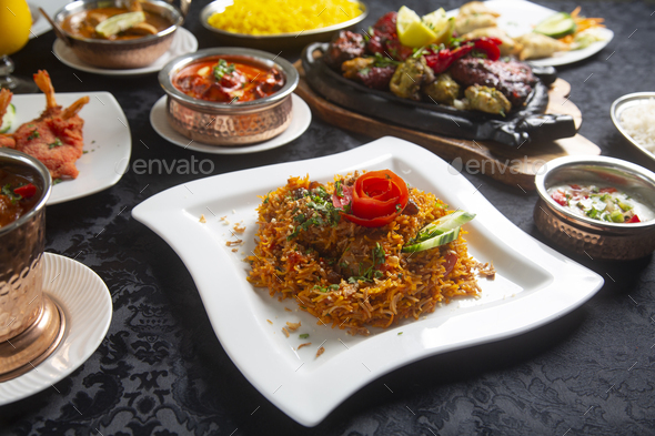 Table with typical Indian dishes, Biryani, chicken curry, tandoori ...