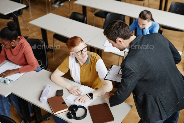 College Professor Helping Student in Class Stock Photo by seventyfourimages