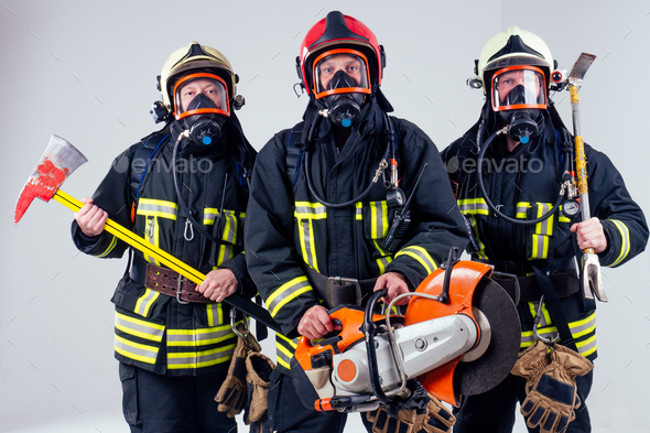 Portrait of three firefighters standing together white background ...