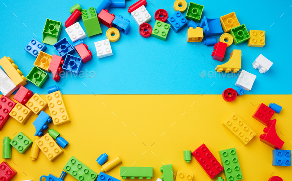 Scattered parts of a plastic children's designer, top view. Yellow blue ...