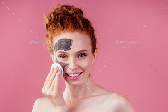 redhaired ginger teenager girl with black clay mask on her pretty face ...