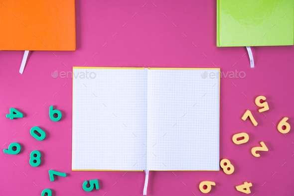 top view of opened blank notebook and math education numbers on pink ...