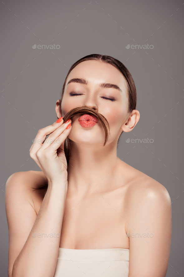beautiful girl pouting lips and holding hair as moustache isolated on ...