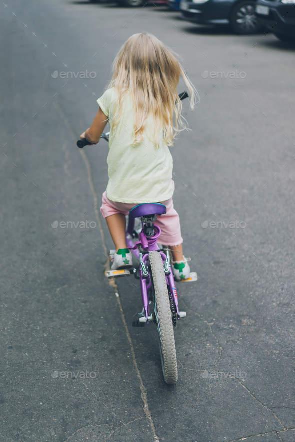 back view of cute kid riding bicycle on street Stock Photo by ...